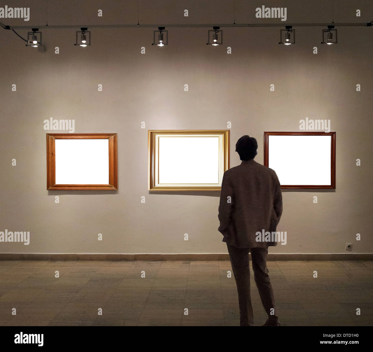 Man in gallery room looking at empty picture frames Stock Photo - Alamy