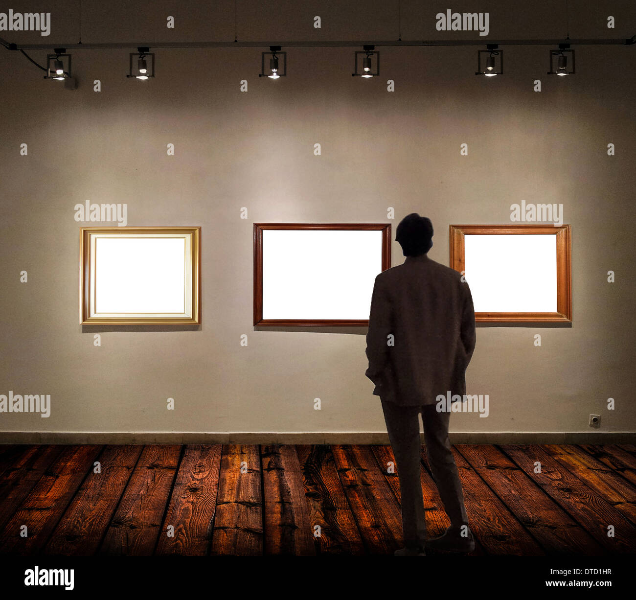 Man in gallery room looking at empty picture frames Stock Photo - Alamy