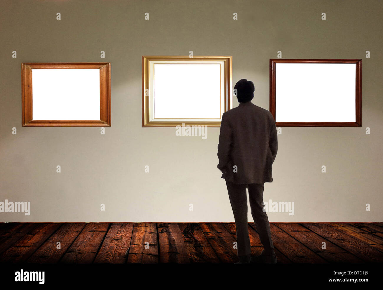 Man in gallery room looking at empty picture frames Stock Photo - Alamy