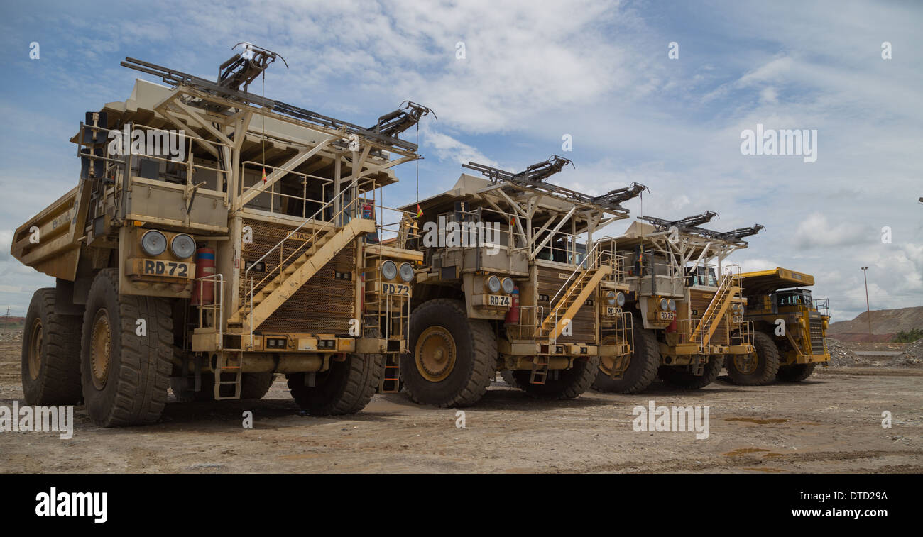 Massive hitatchi and komatsu mining haul trucks parked up in a line in ...