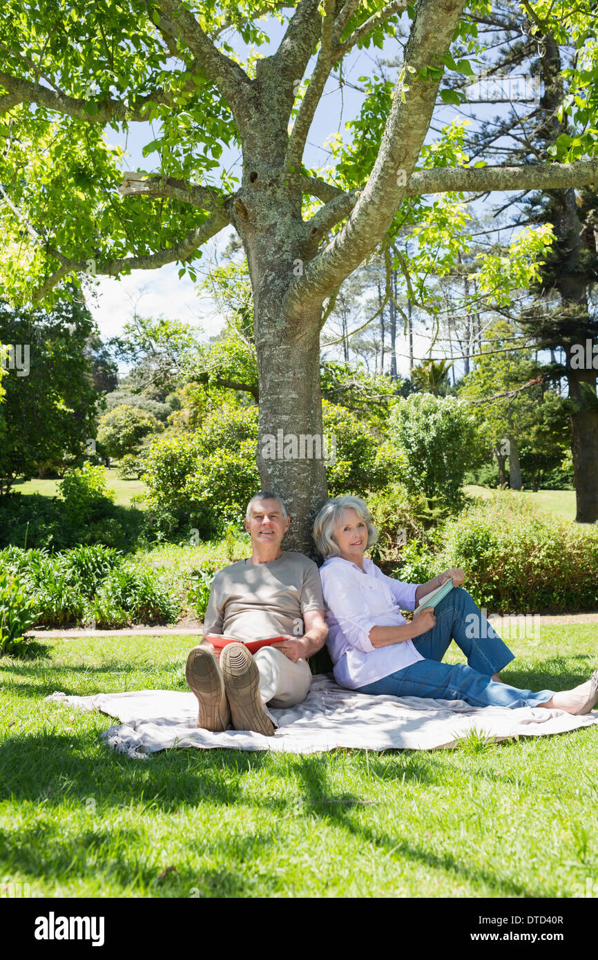 Woman leaning against a tree and reading a book hi-res stock ...