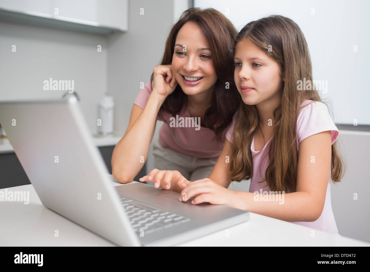 Smiling mother daughter using laptop hi-res stock photography and images - Alamy