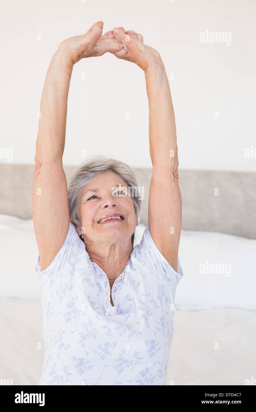 Senior woman stretching on bed Stock Photo - Alamy