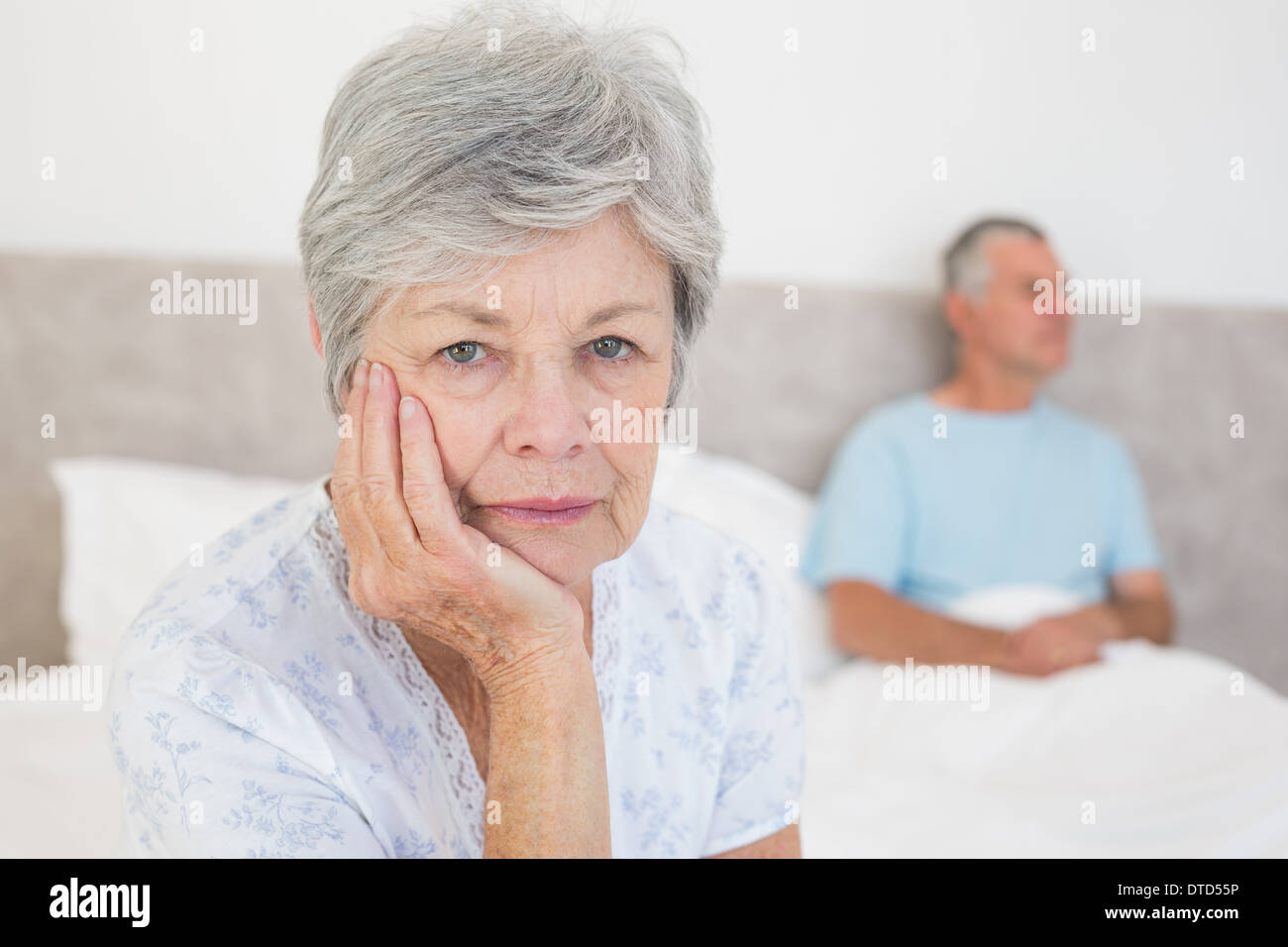 Disappointed senior woman with husband in background Stock Photo - Alamy