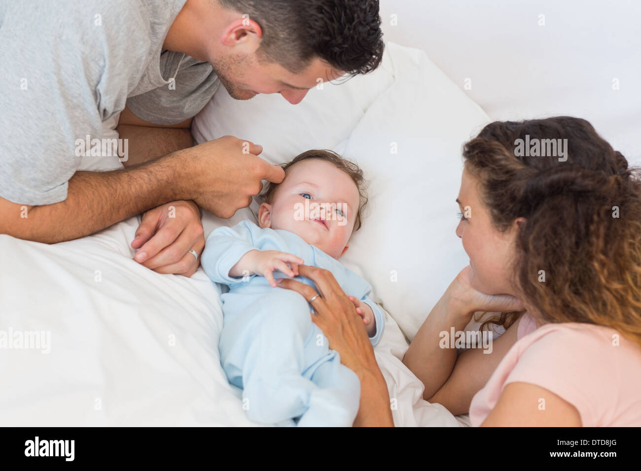 Loving parents playing with baby Stock Photo - Alamy