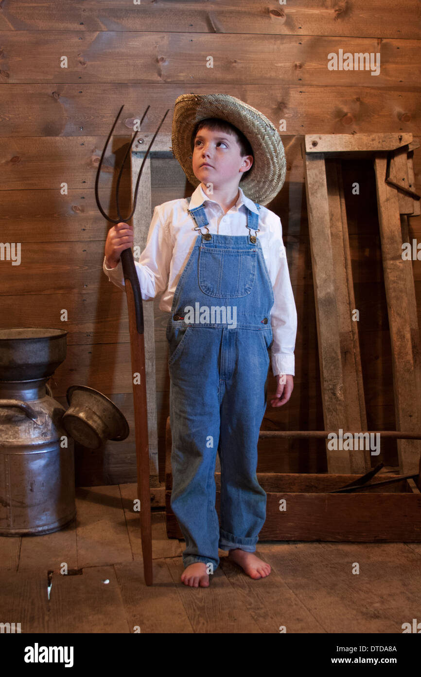 A young farmer boy holding a pitch fork Stock Photo - Alamy