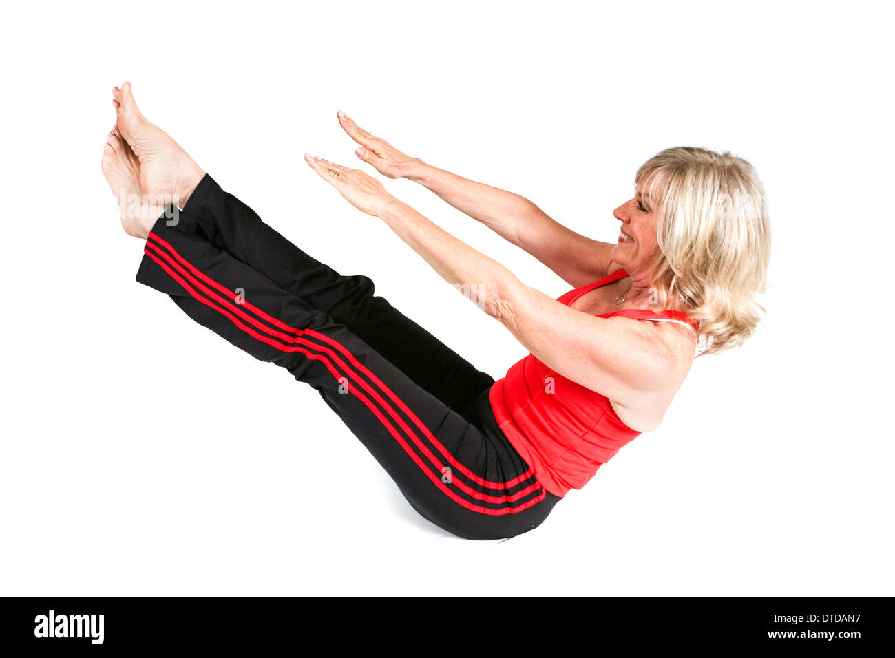 Beautiful senior woman over sixty doing a difficult pilates pose ...