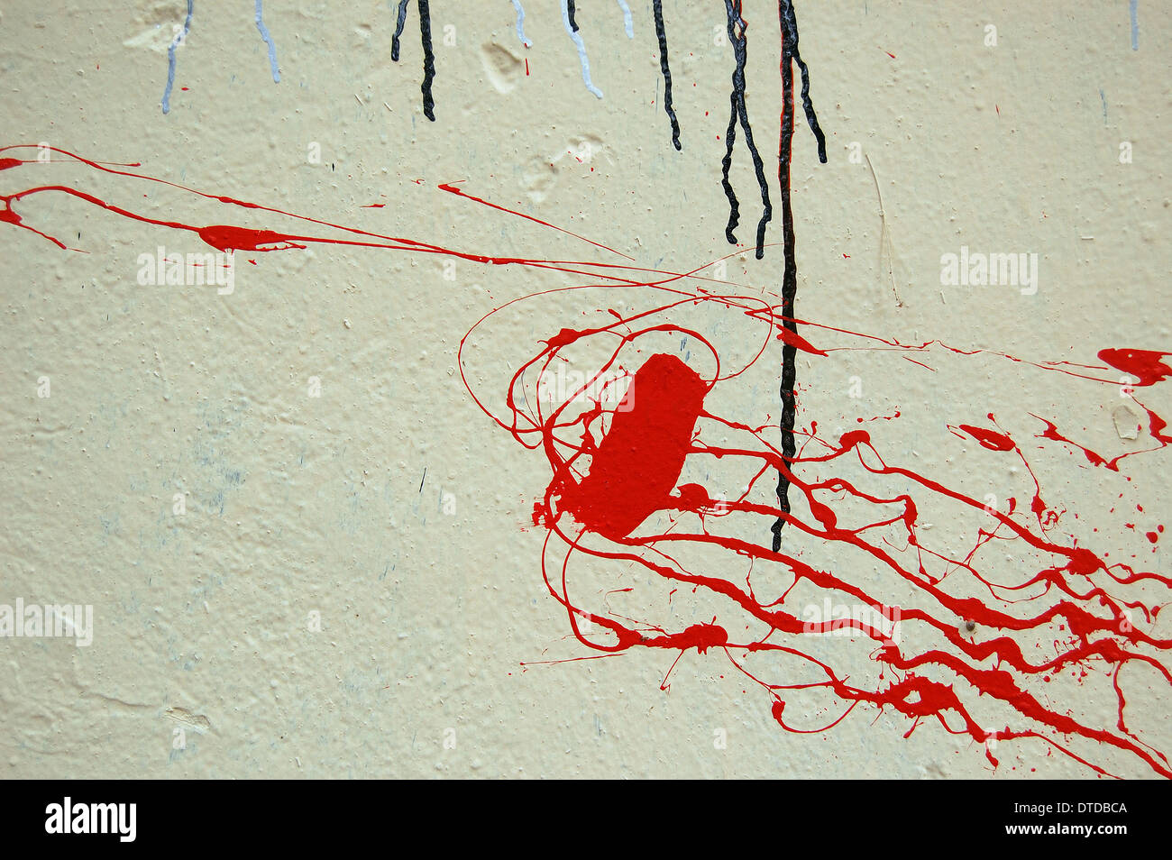 Red color splashed on white textured wall. Dripping paint abstract ...