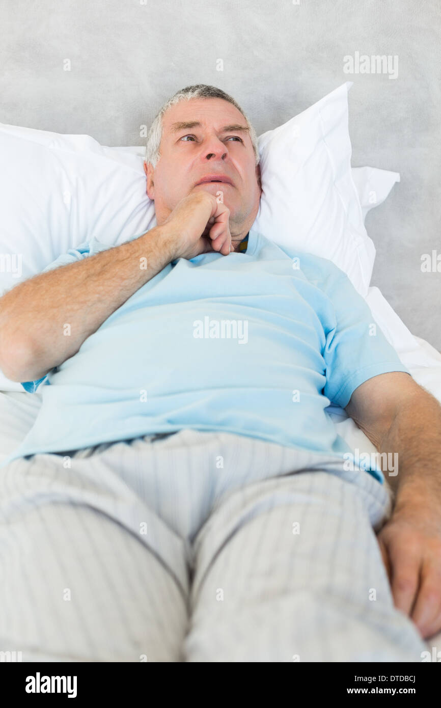 Thoughtful man lying on bed hi-res stock photography and images - Alamy