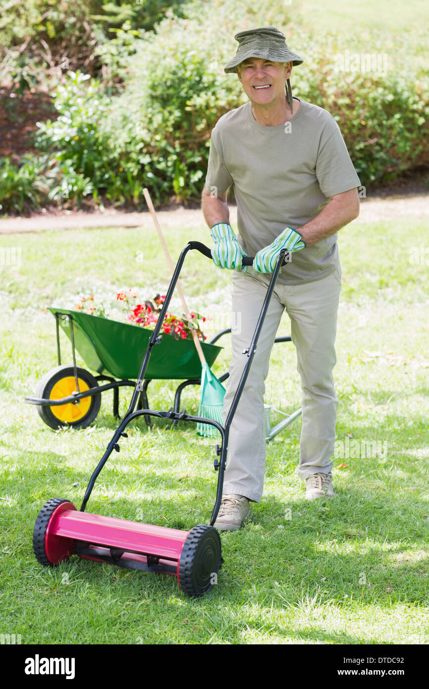 Smiling man mowing lawn Stock Photo - Alamy