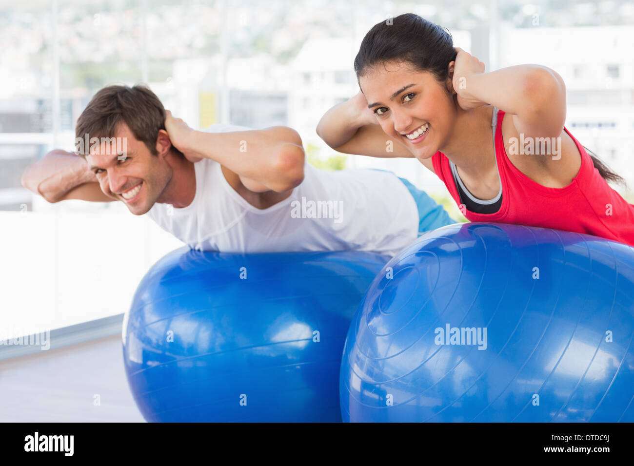 Fit couple exercising on fitness balls in gym Stock Photo - Alamy