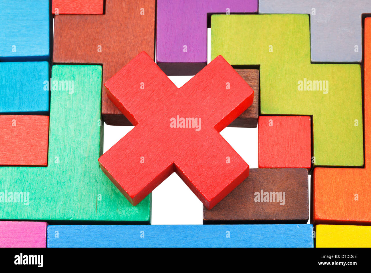 cross shaped piece on wooden multicoloured puzzle isolated on white ...