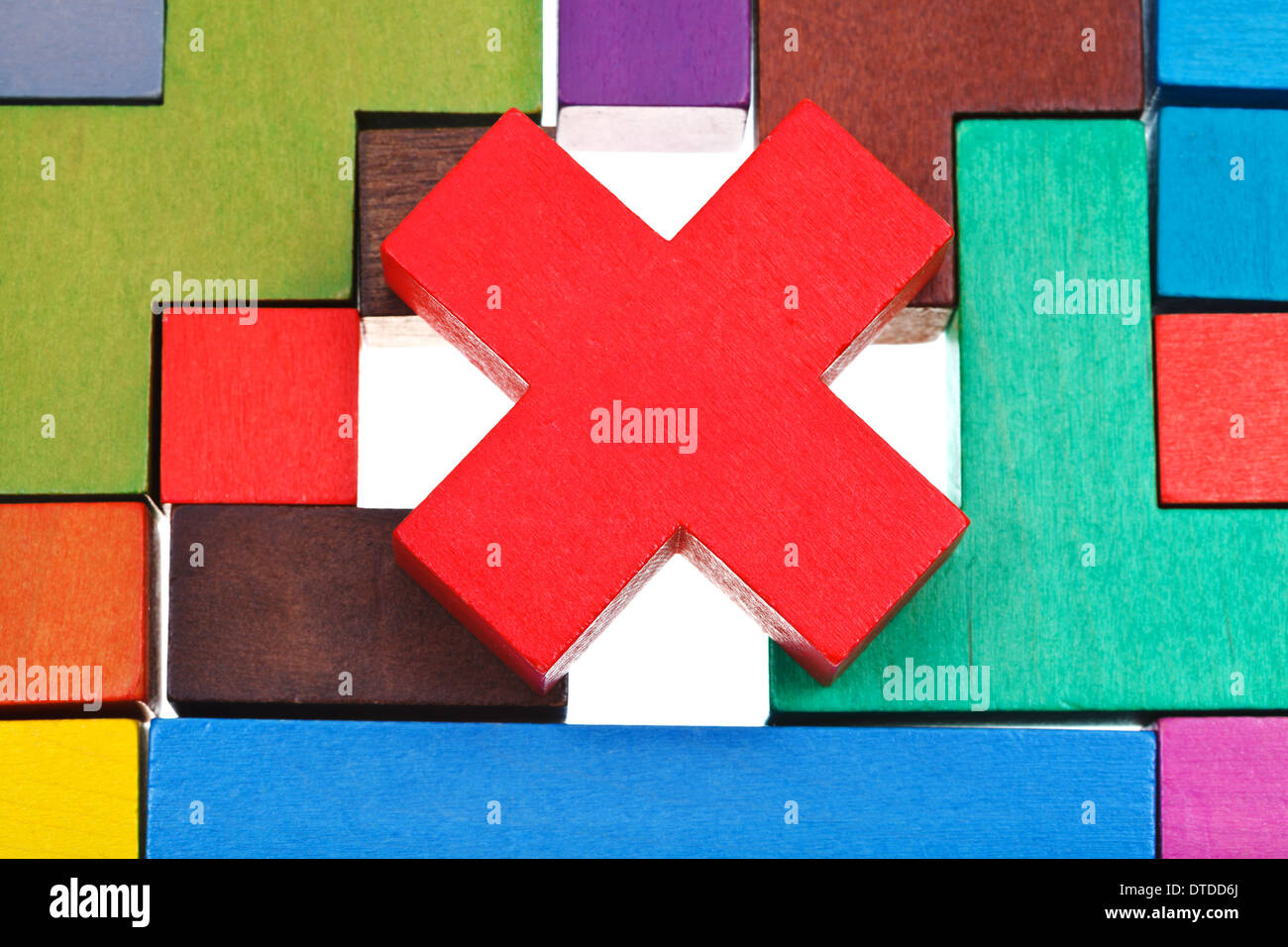 cross shaped block on wooden multicoloured puzzle isolated on white ...