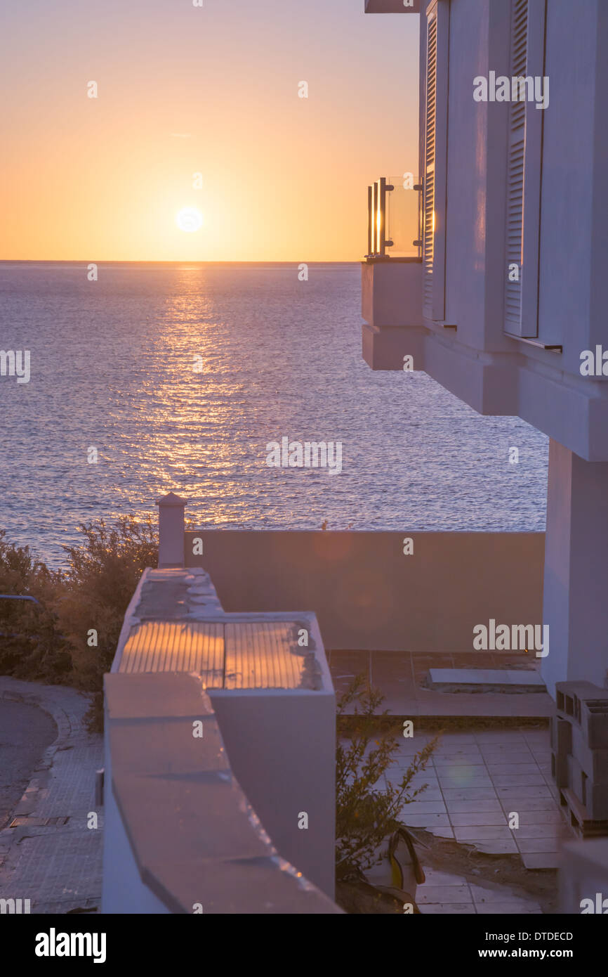 Sun setting in the Mediterranean next to a luxury residential building ...
