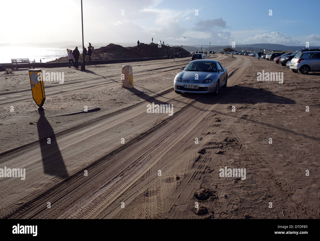 Exmouth beach, post storm damage, cars drive on the sand covered road ...