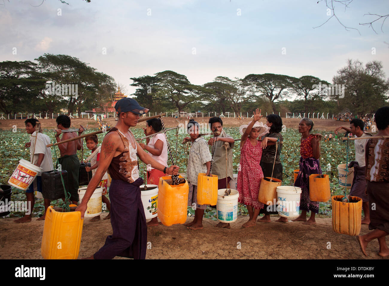 A man fill containers with water in a small lake in Dala Township ...