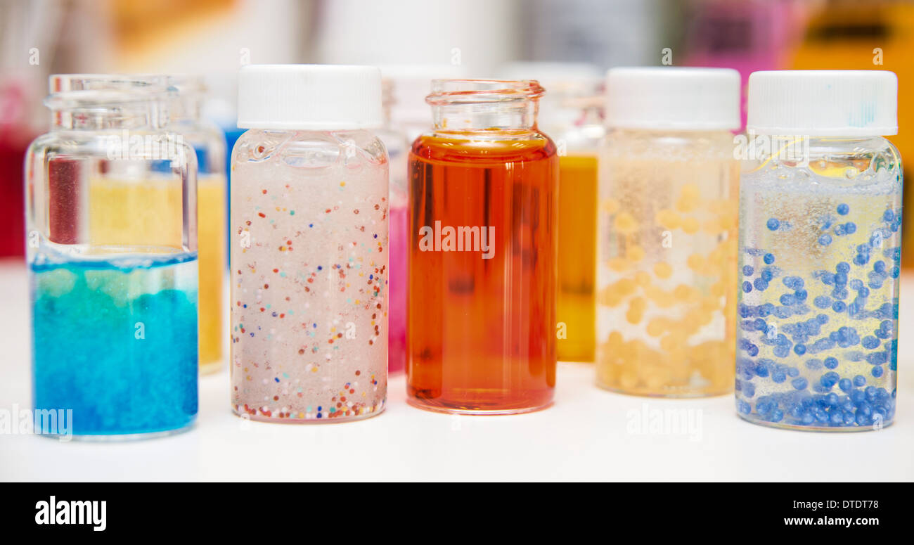 Glass bottles with coloured liquid at a Cosmetics manufacturer Stock ...