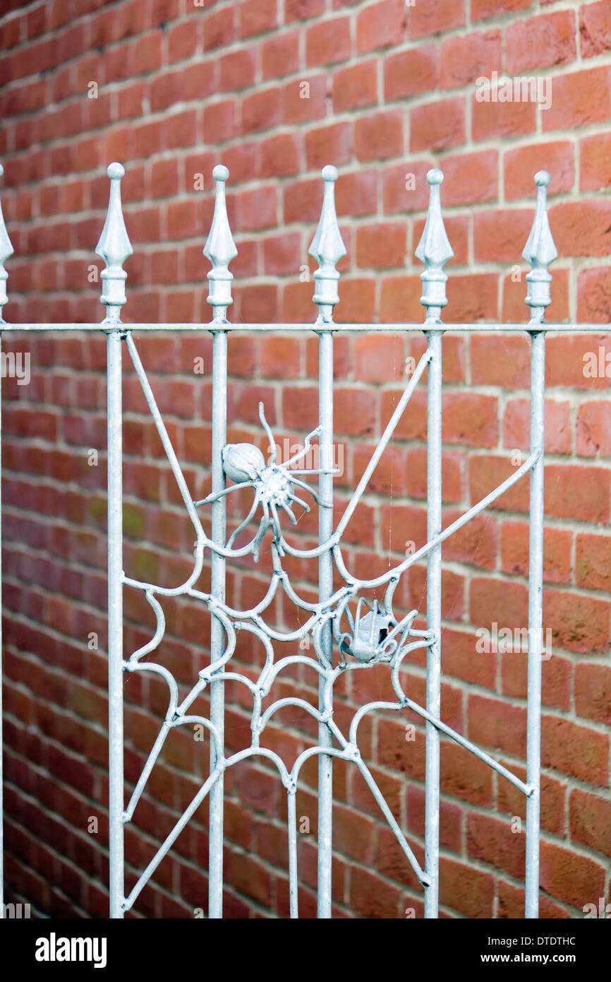 sculptured metal spider with web and prey on railings Stock Photo - Alamy