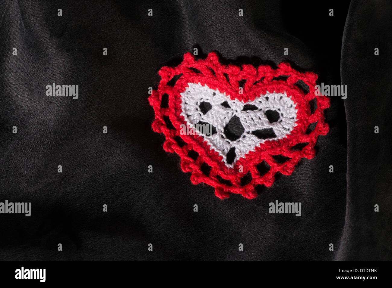 Heart shape made of red textile on black satin Stock Photo - Alamy