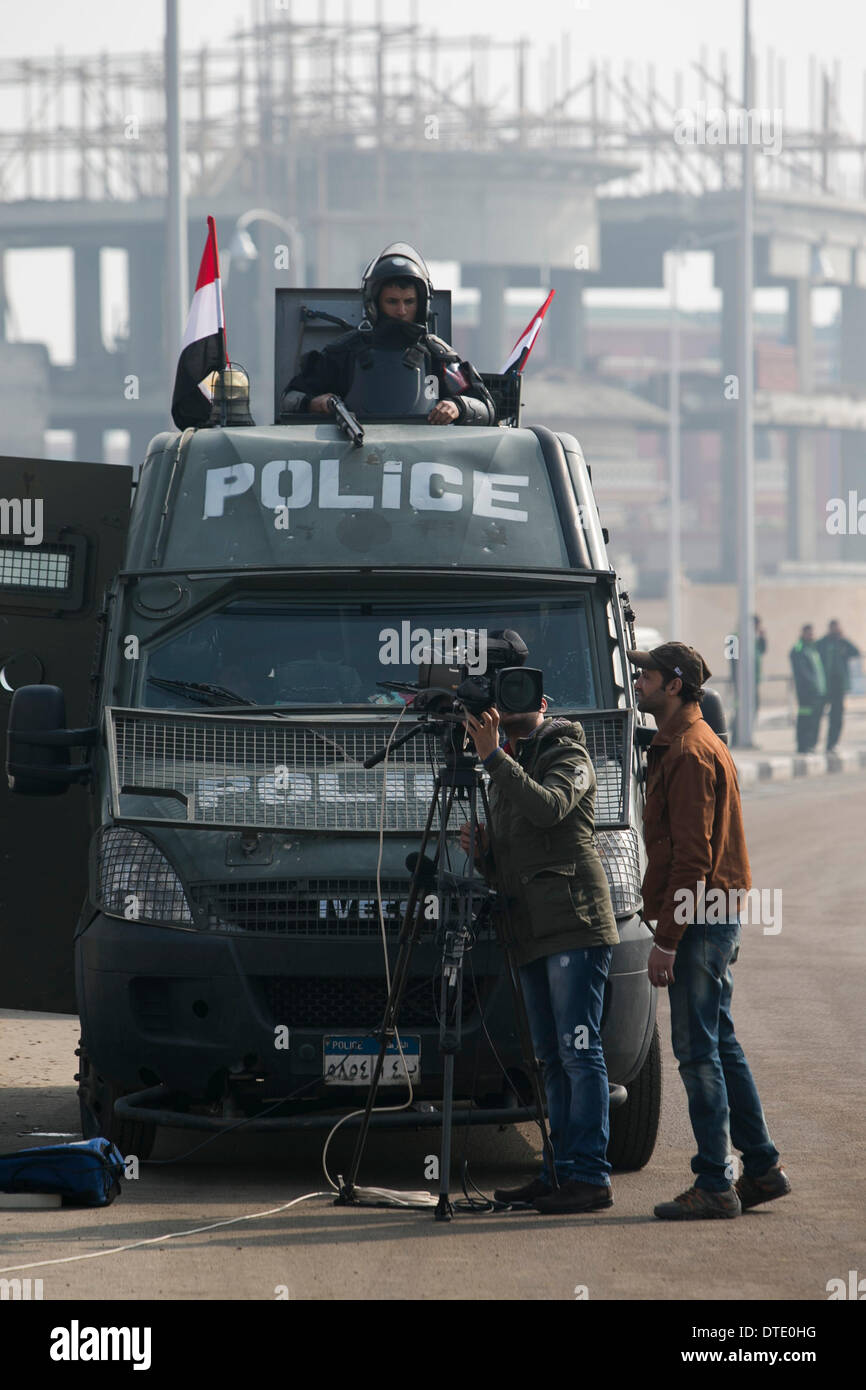 Cairo, Egypt. 16th Feb, 2014. TV crews stand up by a police van in ...