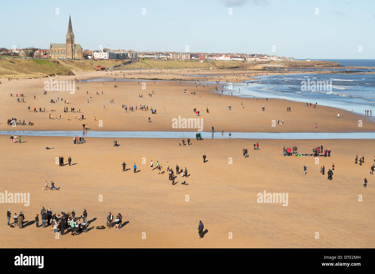 February sunshine on Tynemouth beach, people enjoying playing sports ...
