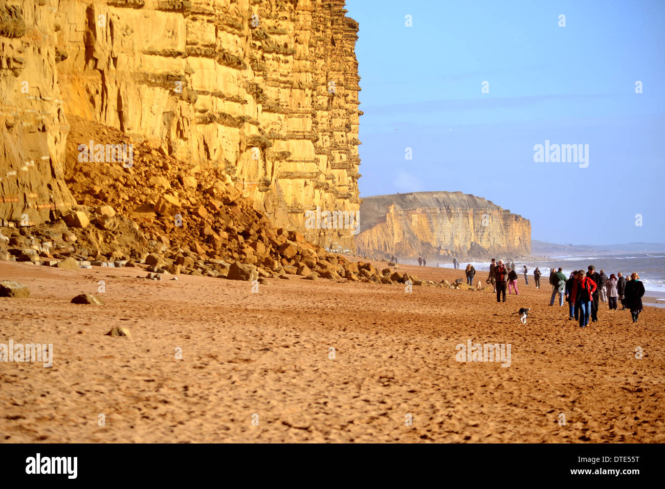 People walk past a pile of fallen rocks after a section of the cliffs ...