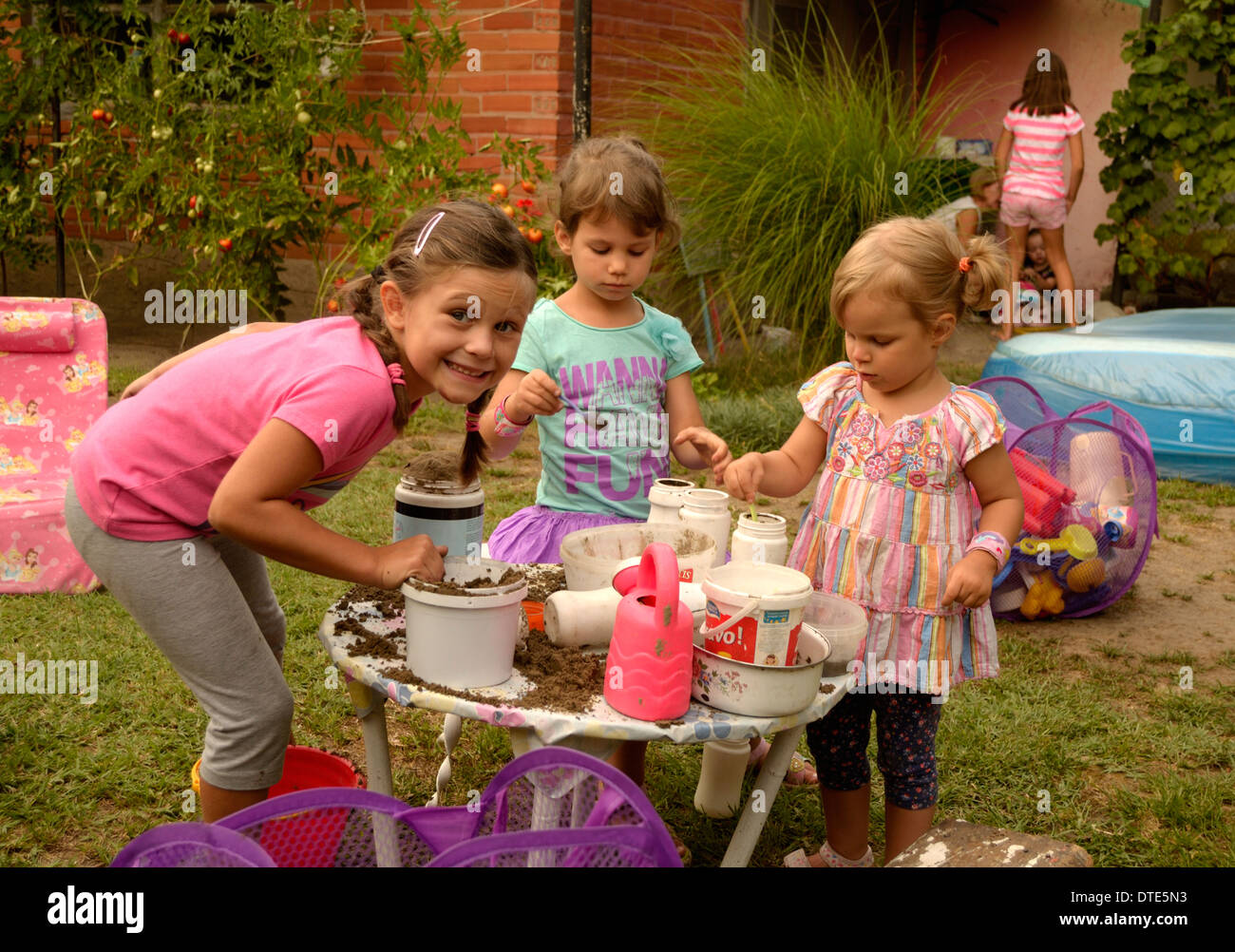 Children playing in a garden party with sand Stock Photo - Alamy