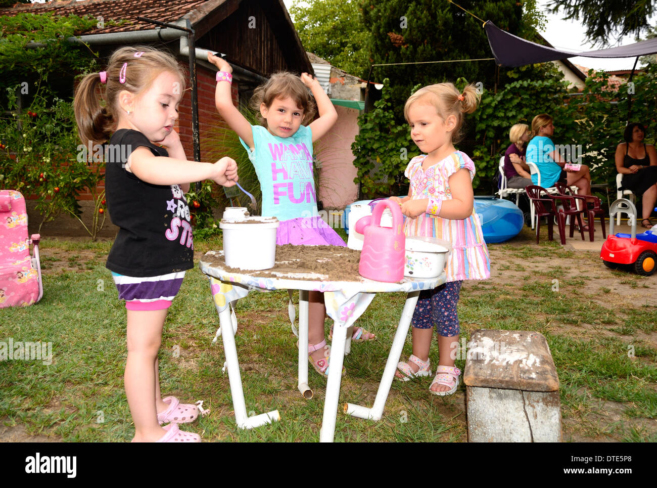 Children playing in a garden party with sand Stock Photo - Alamy