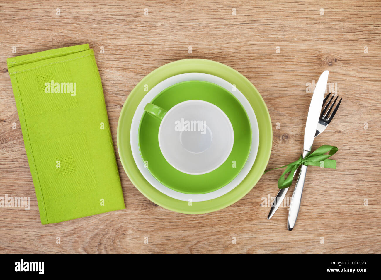 Kitchen utensils, plates, silverware over wooden table with copyspace ...
