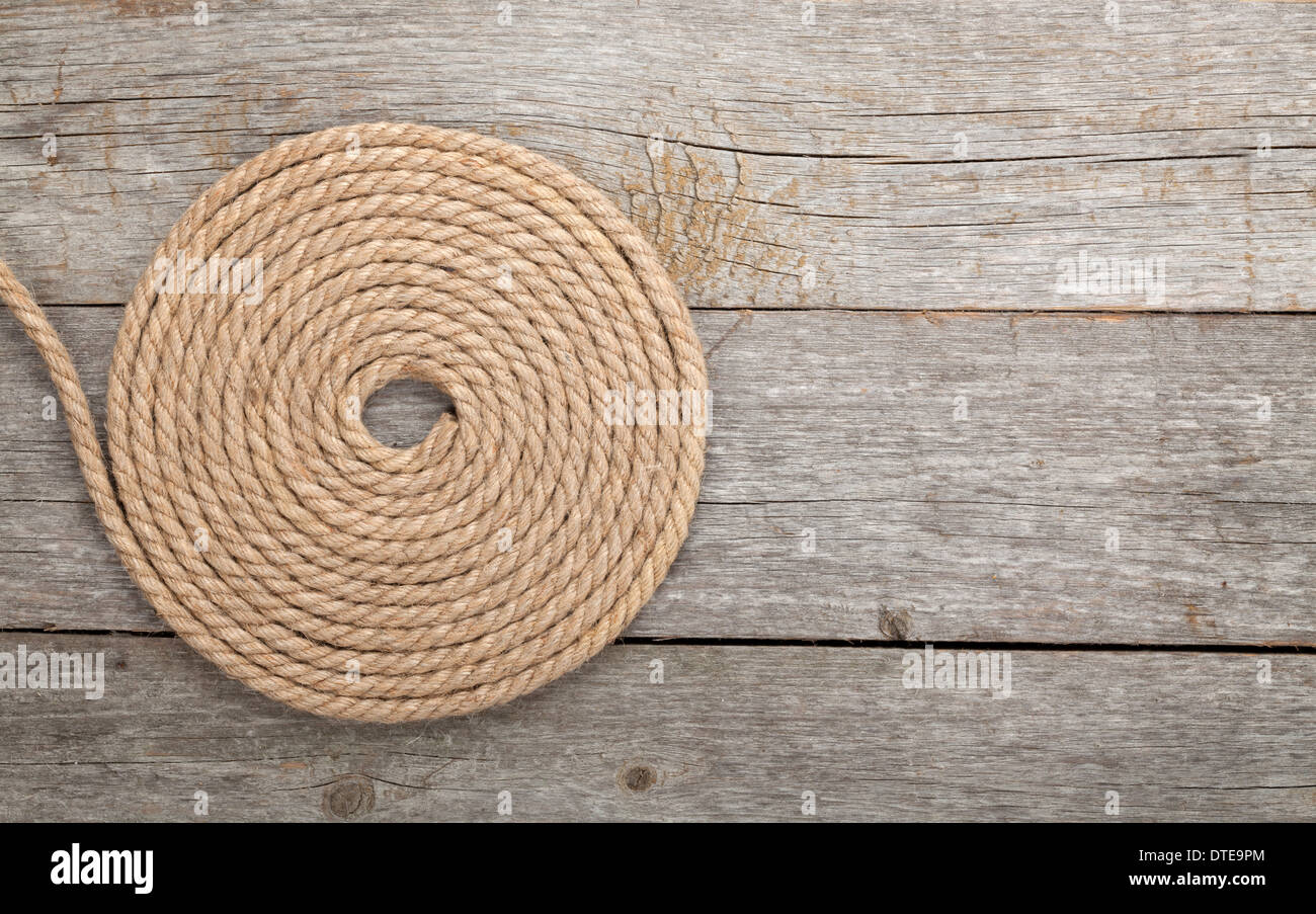 Roll of ship rope on wooden texture background Stock Photo - Alamy