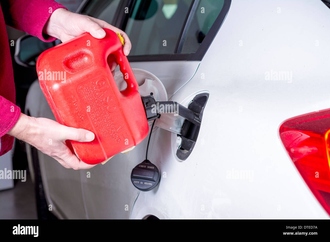 Adding gas to a car with a can Stock Photo - Alamy