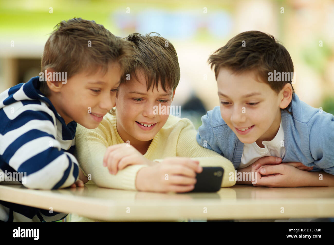 Three boys surfing the net on smartphone Stock Photo - Alamy