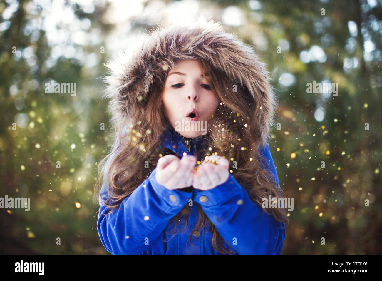 Portrait of young woman blowing snow Stock Photo - Alamy