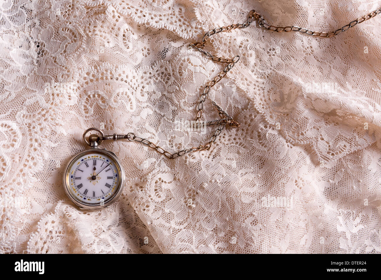 Old pocket watch lying on layers of vintage lace Stock Photo - Alamy