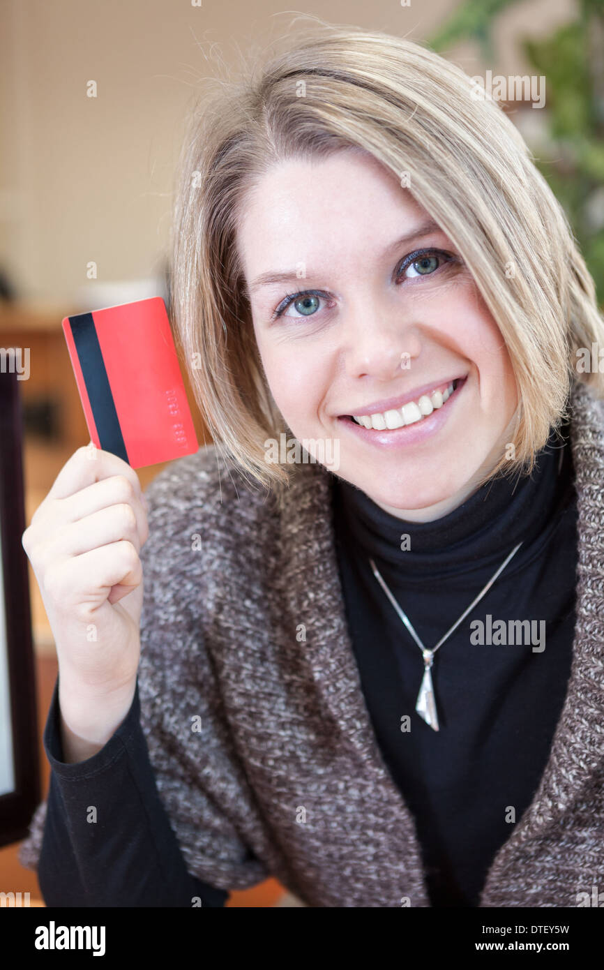 Smiling Caucasian woman showing credit card in hand Stock Photo - Alamy