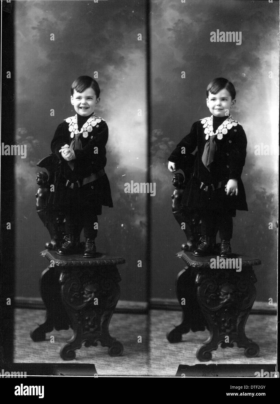 This 1912 portrait photograph features a young boy sitting on a chair ...