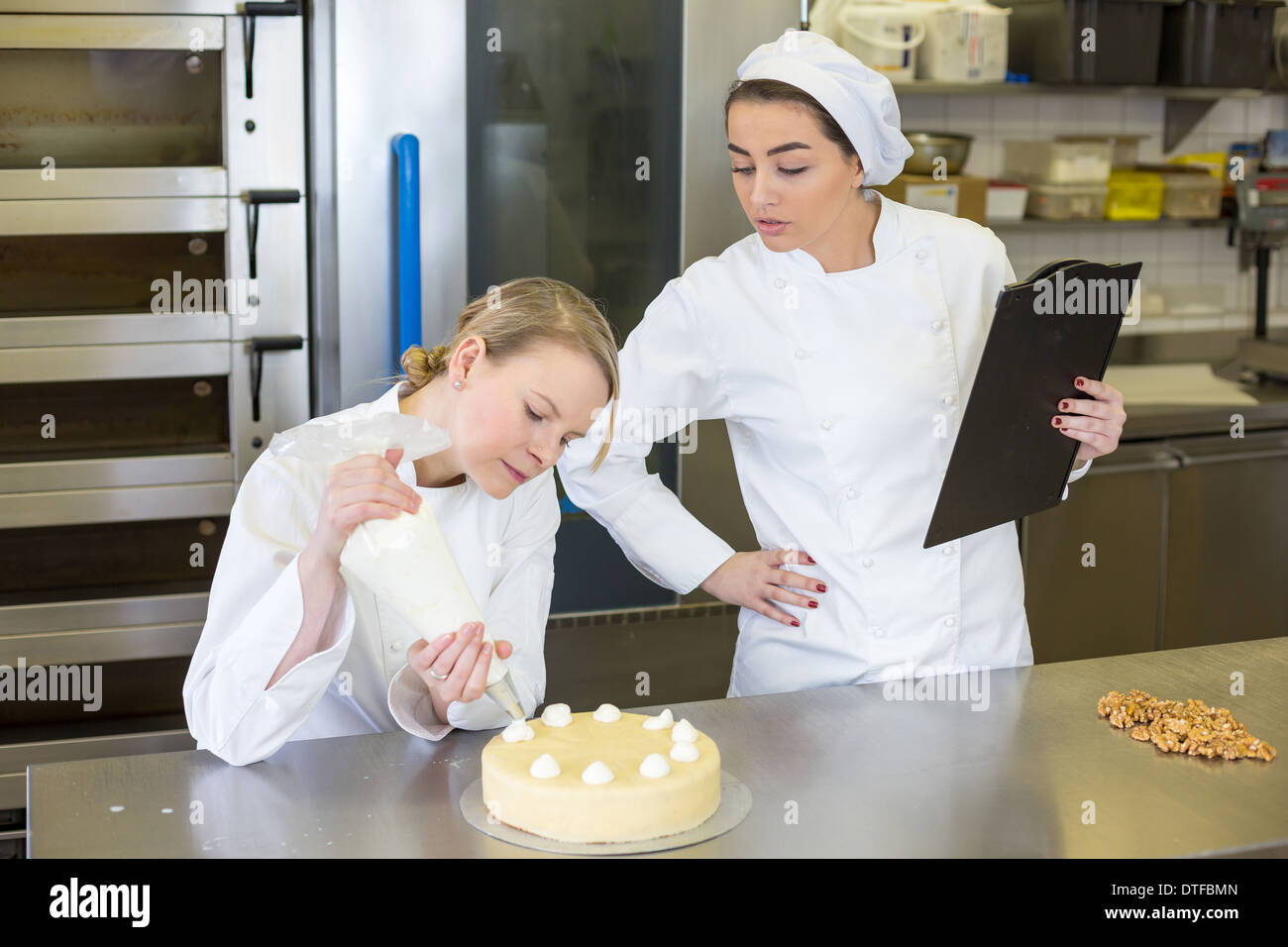 instructor in bakery teaching apprentice how to make cake Stock Photo ...