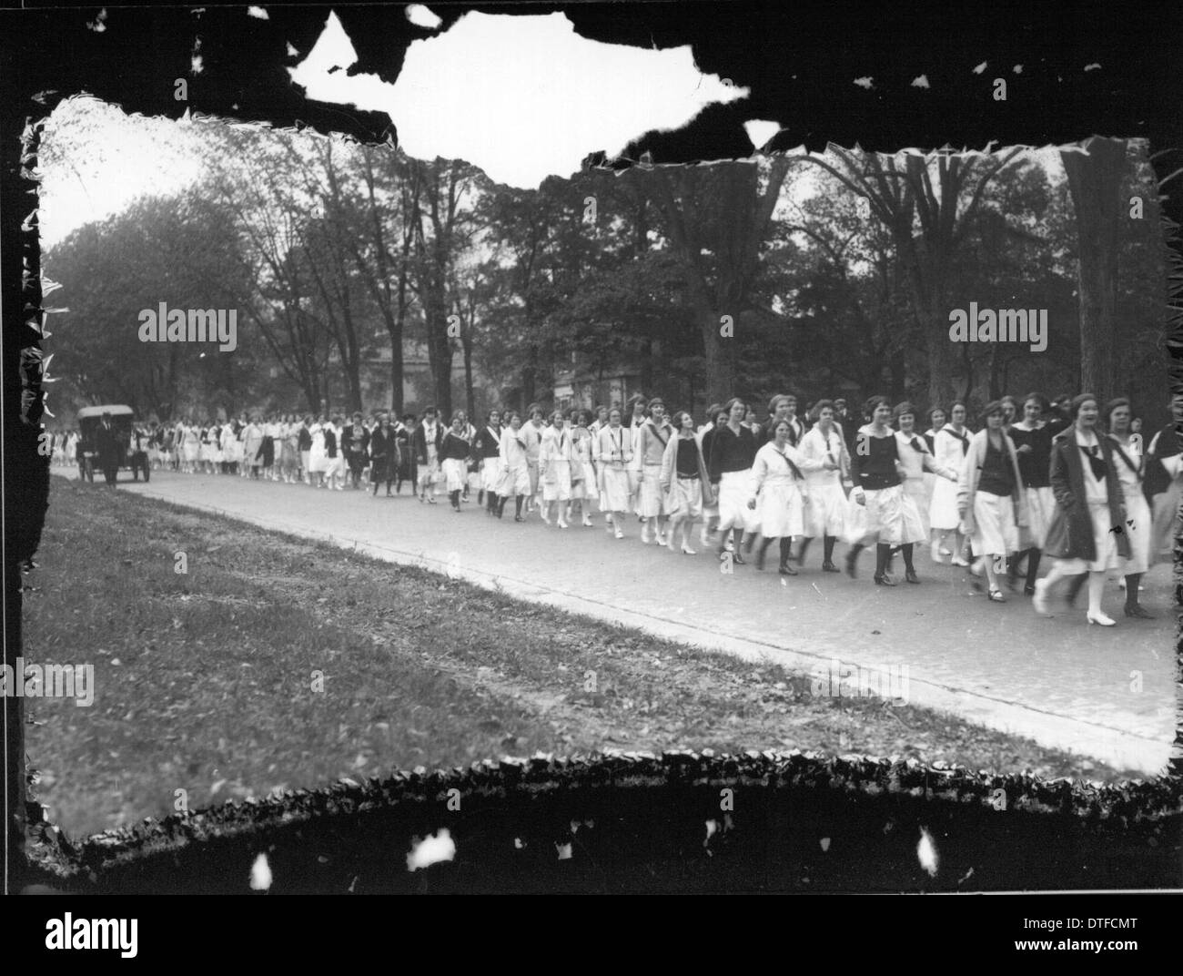 This photograph captures a women's procession, likely tied to events ...