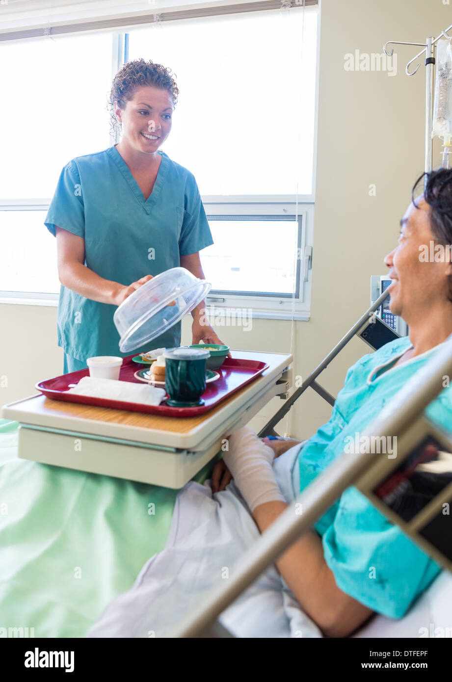 Nurse Lifting Cover From Food Plate For Patient In Hospital Stock Photo ...