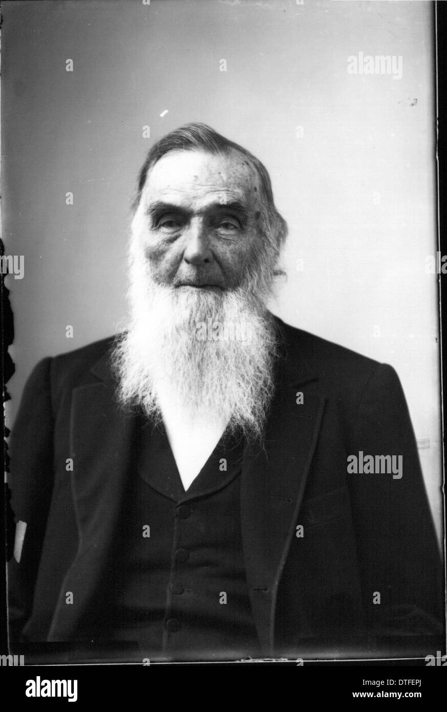 This portrait photograph captures an elderly bearded man in a suit ...