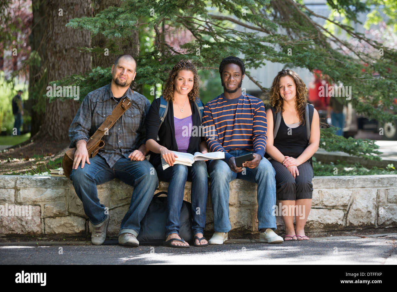 Portrait Of University Students Sitting On Campus Stock Photo - Alamy