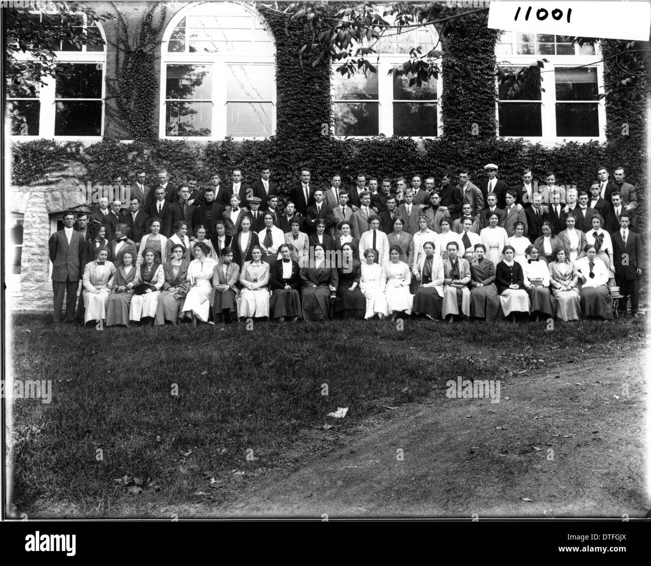 This historical photograph shows a large group of individuals outside ...