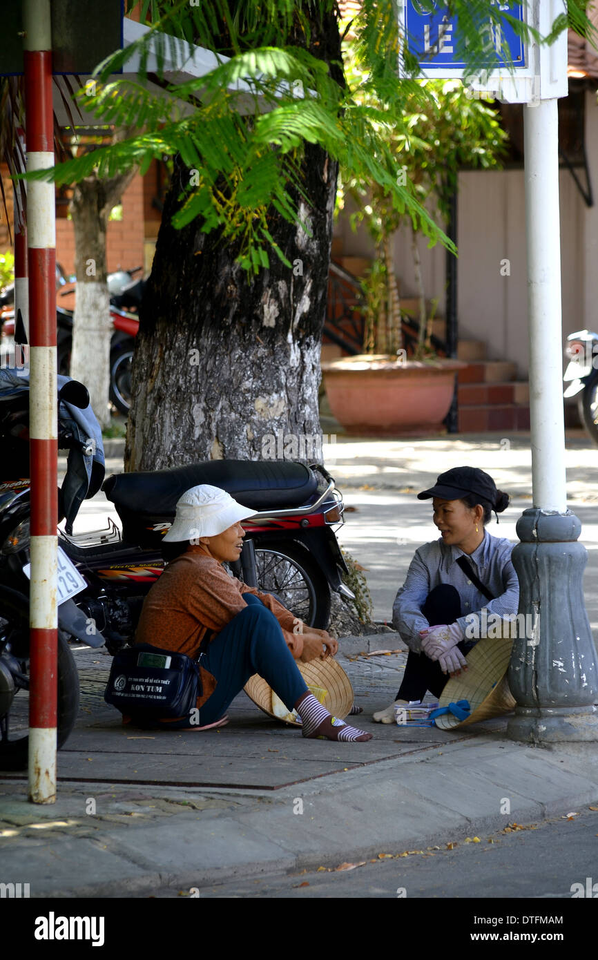 Vietnamese women sitting at street corner chatting Stock Photo - Alamy
