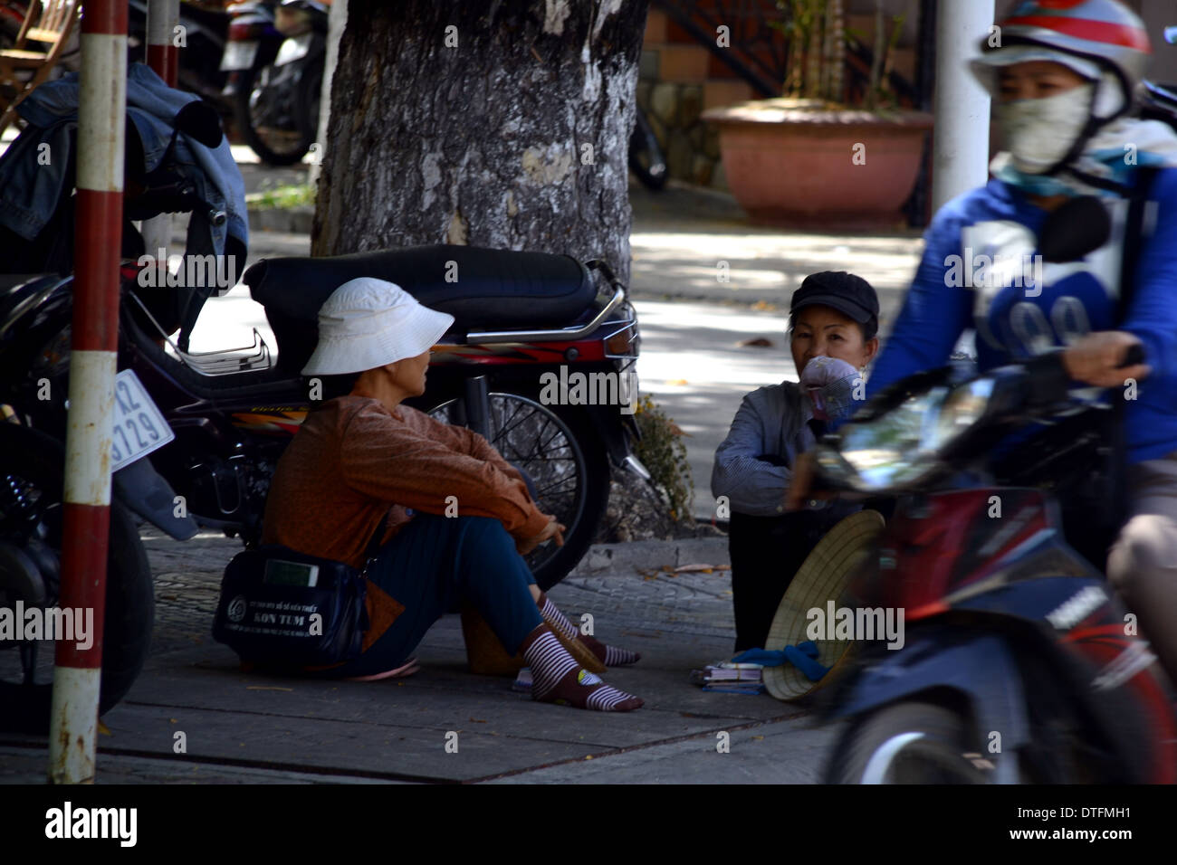 Vietnamese women sitting at street corner chatting Stock Photo - Alamy