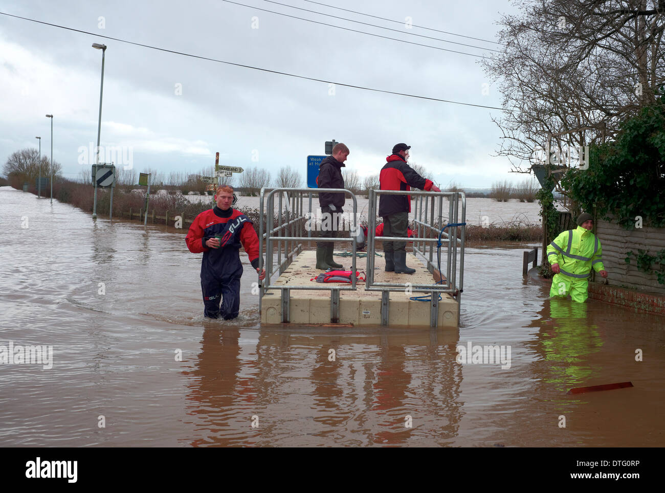 Volunteers using a floating in to ferry equipment around floods in ...