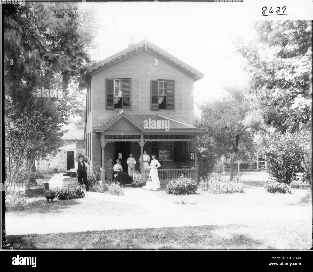 This historical photograph from 1908 shows a family standing in front ...