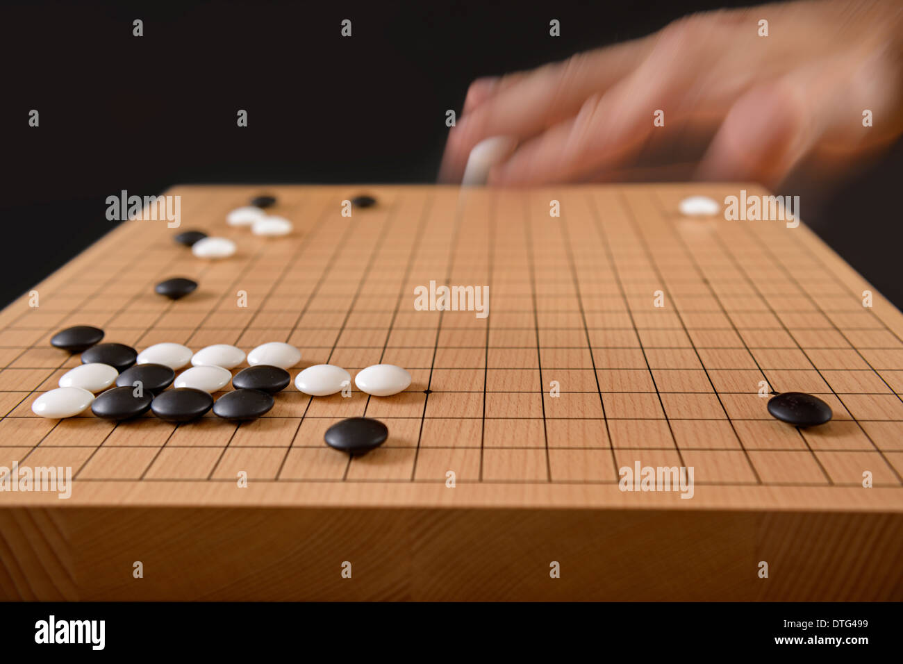 Someone playing go, showing movement Stock Photo - Alamy