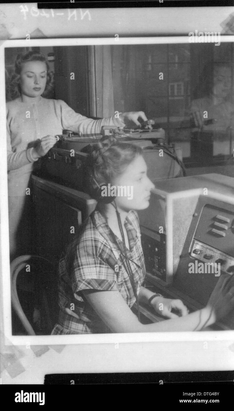 This historical photograph shows two women working with radio equipment ...