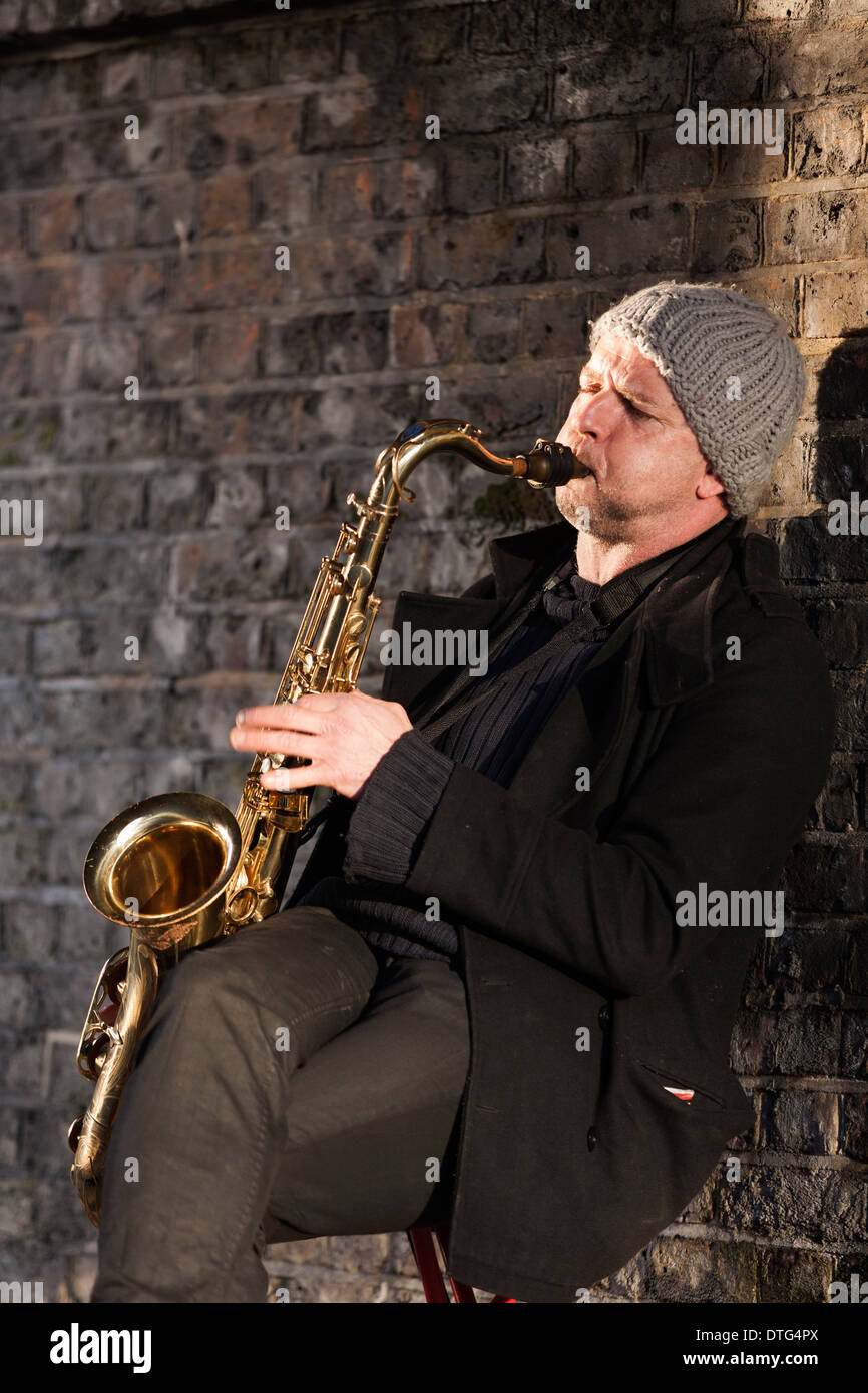 Busker busking / street player / saxophonist playing the saxophone ...