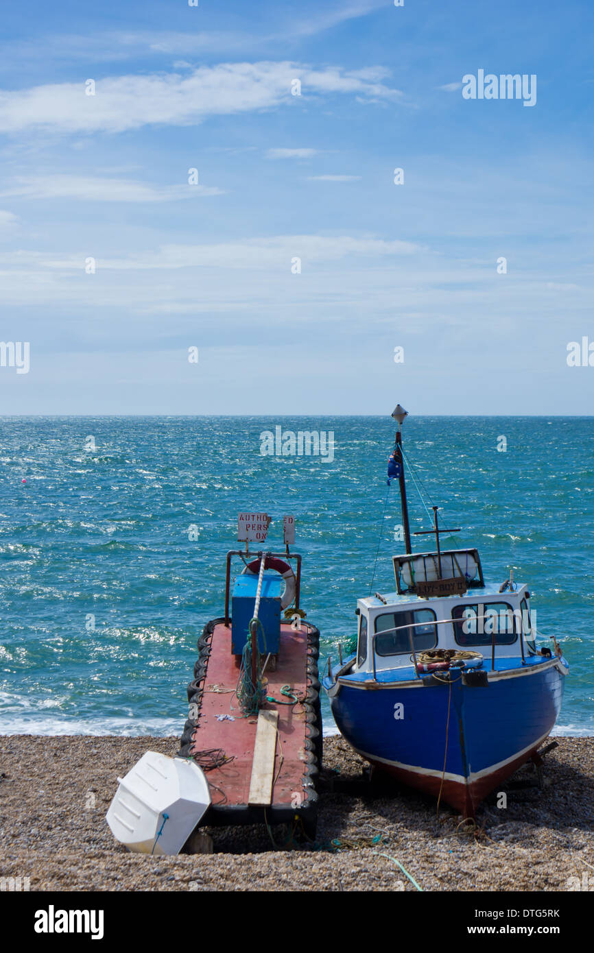 A coastal scene of a beach, sea, sky and a fishing boat Stock Photo - Alamy
